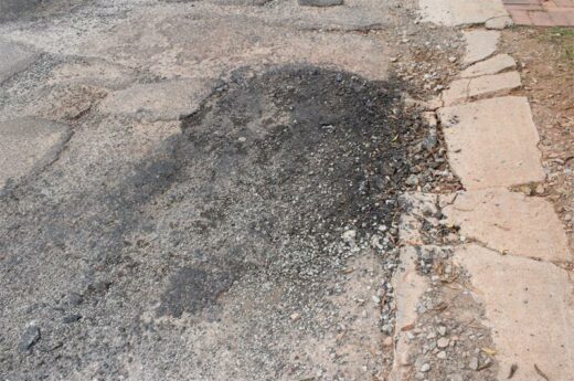 Pothole-infested road remains damaged