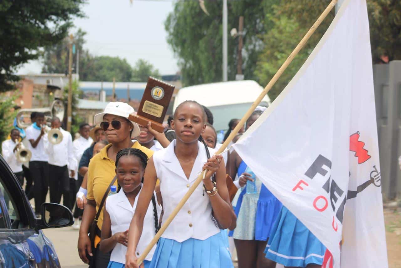 Alexandra Field Band showcases their trophies in a victory parade ...