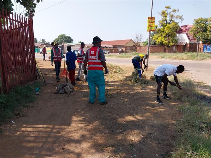 Volunteers cut overgrown grass outside school | Rekord