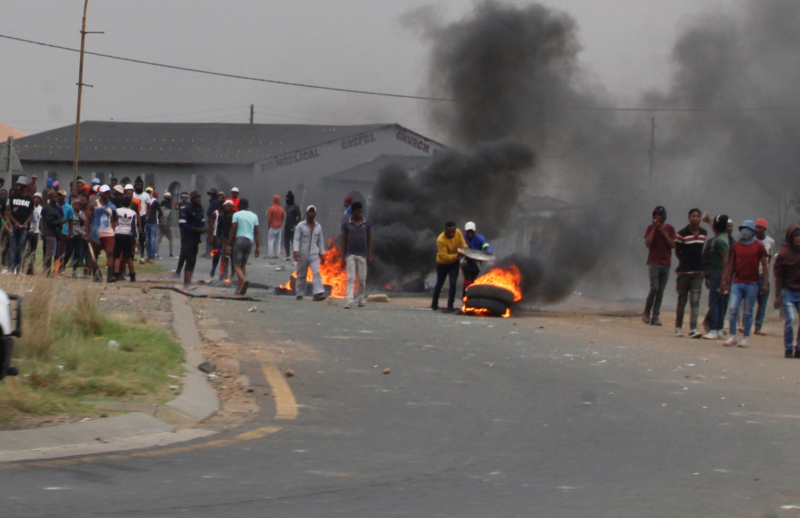 VIDEO - Children run for safety as protesters set alight tyres near ...