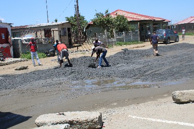 Residents of eMbalenhle repair and maintain road to their clinic ...